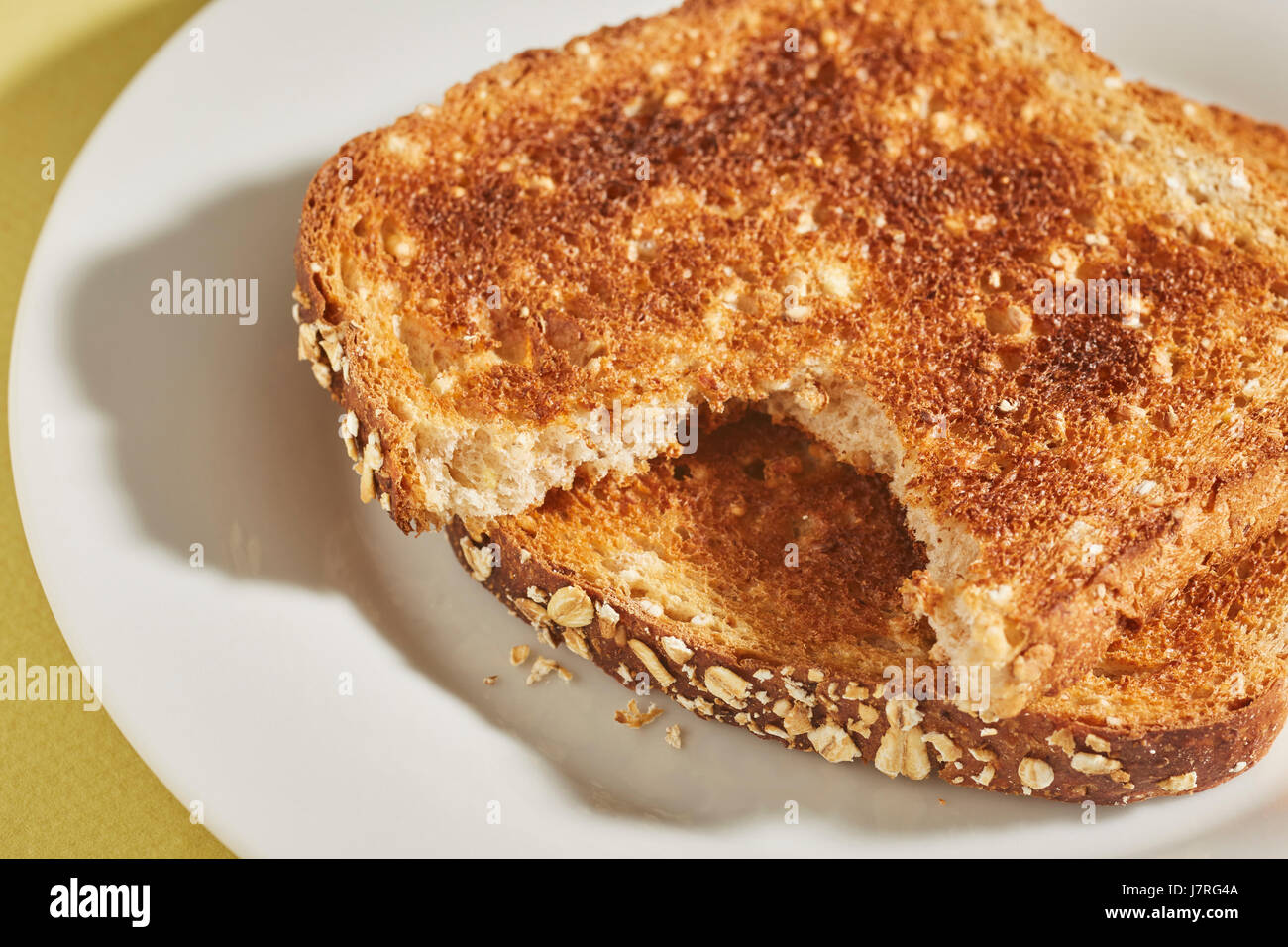 two slices of whole grain toast, one with a bite taken Stock Photo - Alamy