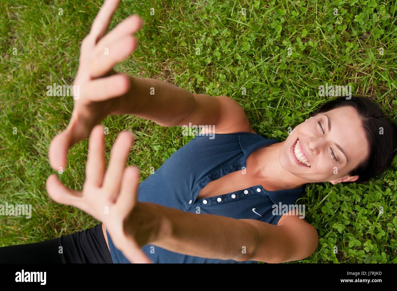 woman hand hands person lie lying lies down above meadow grass lawn ...