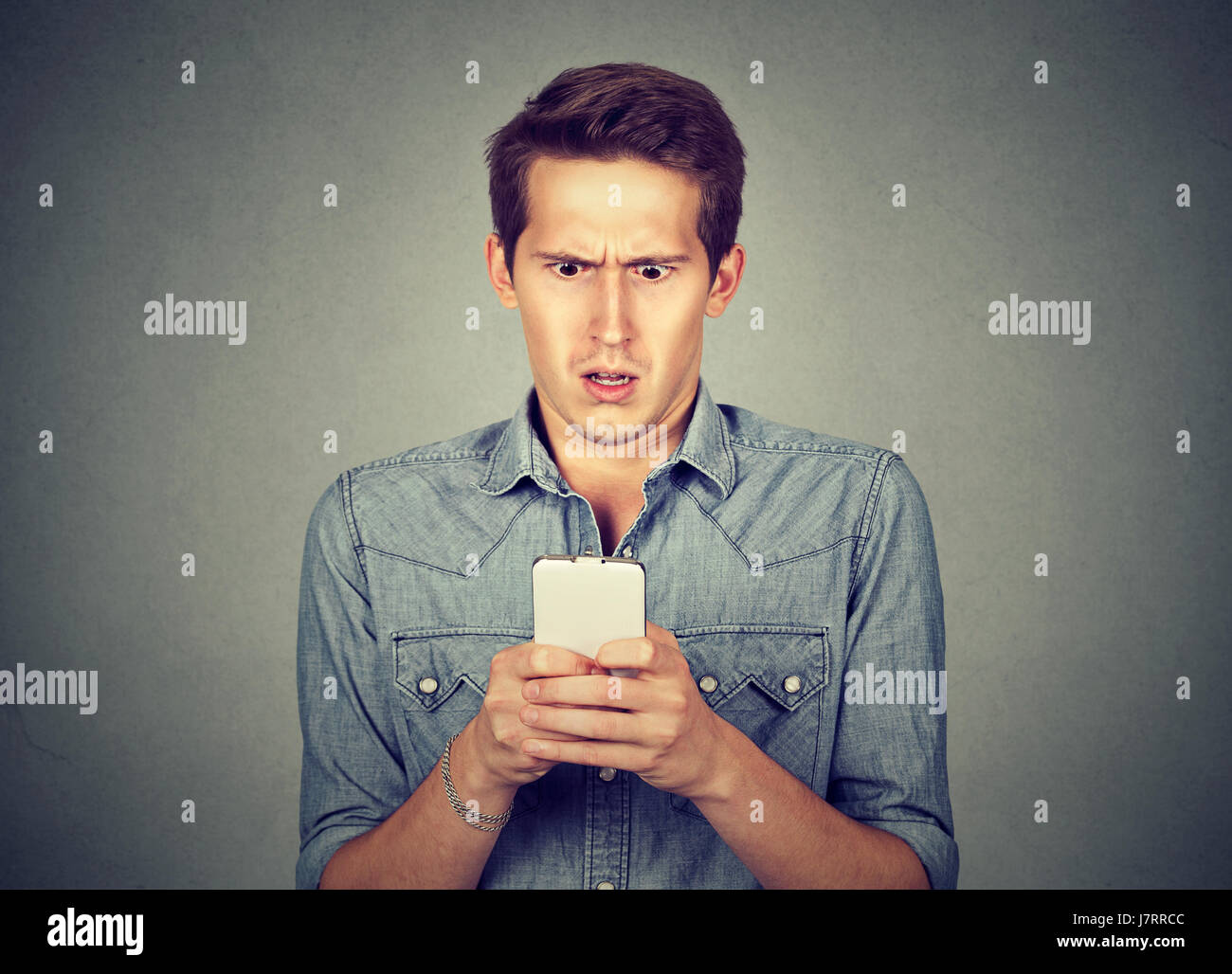 Shocked man checking his mobile phone Stock Photo - Alamy