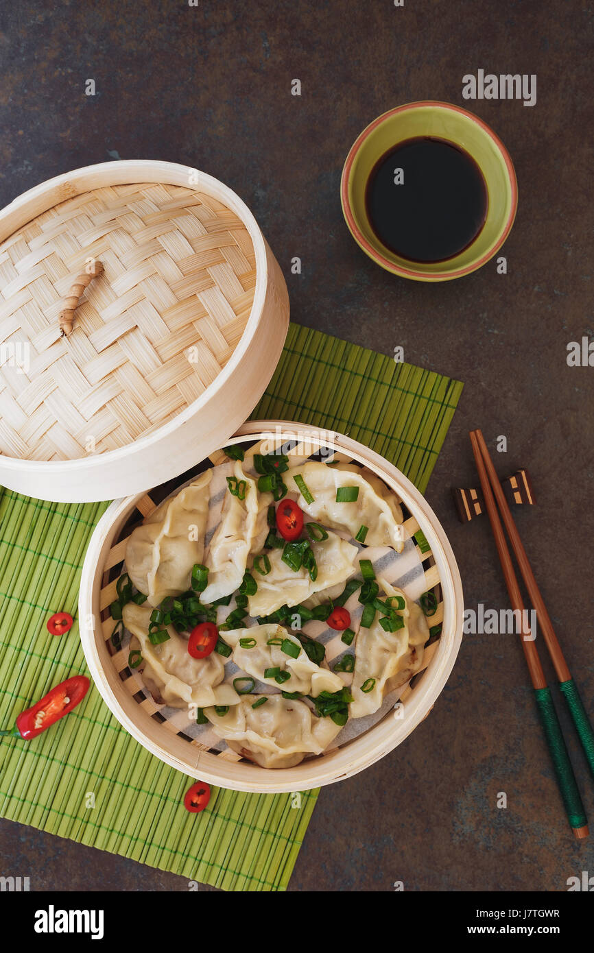 Gyoza potstickers or dumplings in bamboo steamer with sliced spring ...