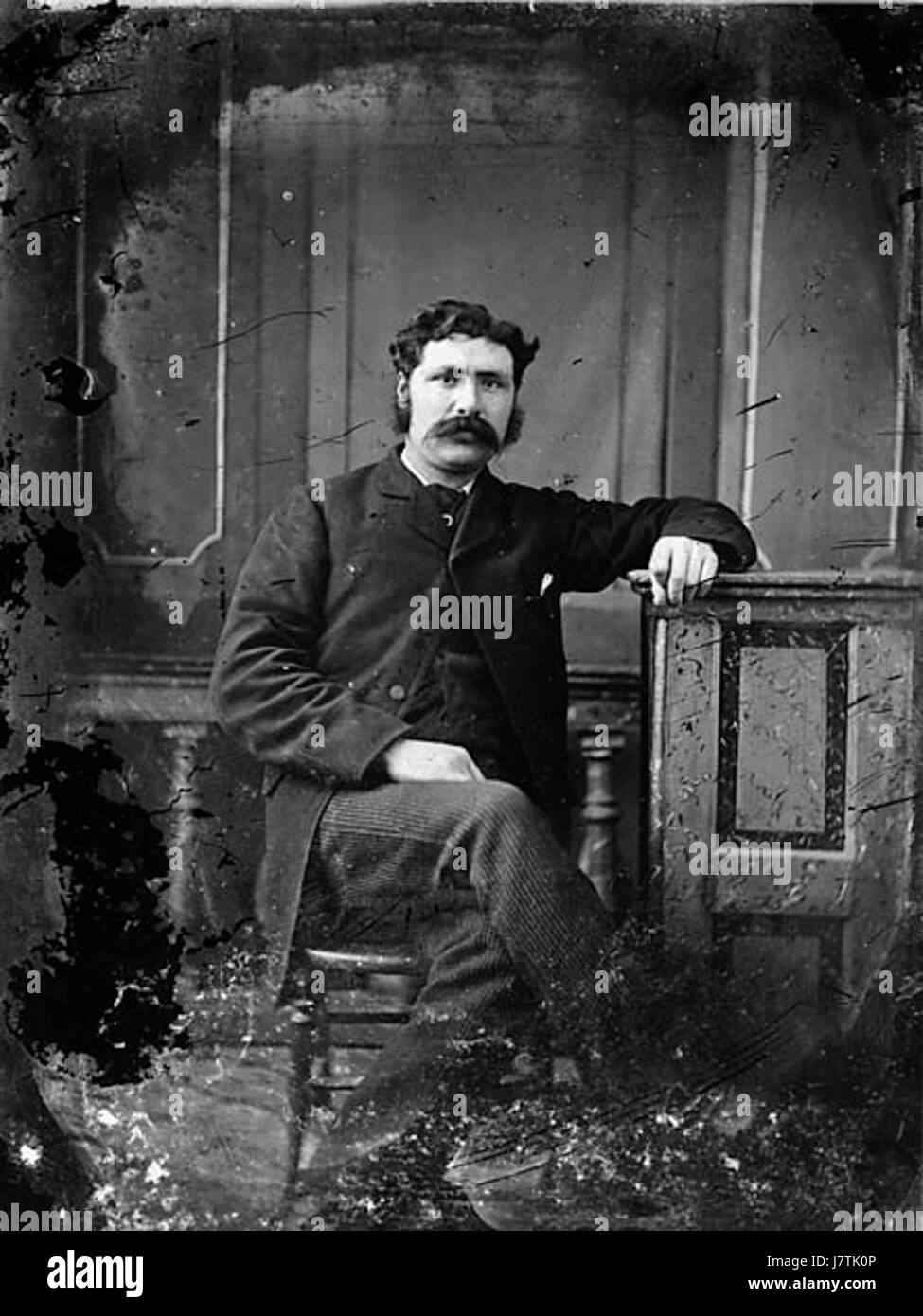 This image depicts a man seated, possibly in a reflective or ...
