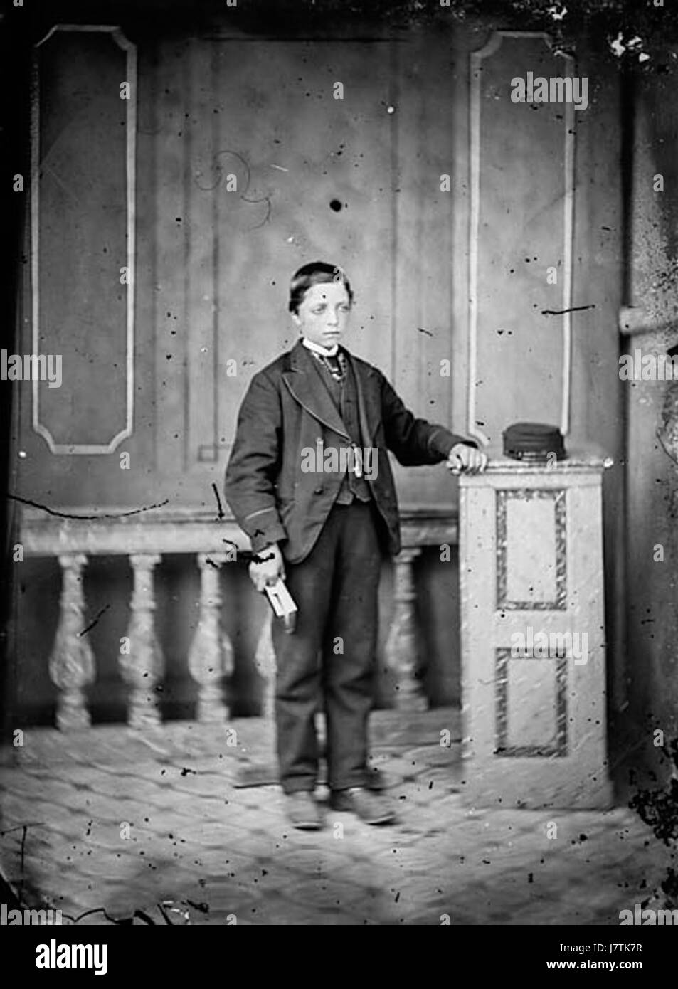 This photograph shows a young man standing, possibly from a historical ...