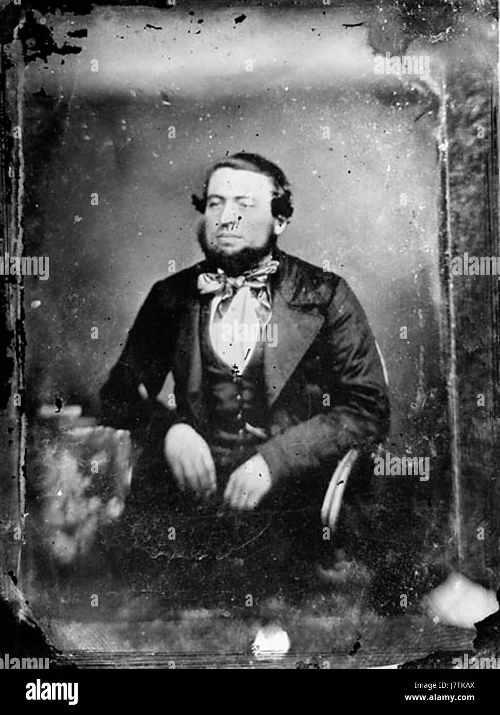 This image depicts a man sitting, likely captured in a candid or posed ...