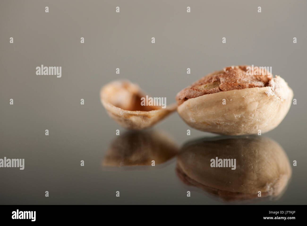Open pistachio on a glass plate with adjacent shell Stock Photo - Alamy