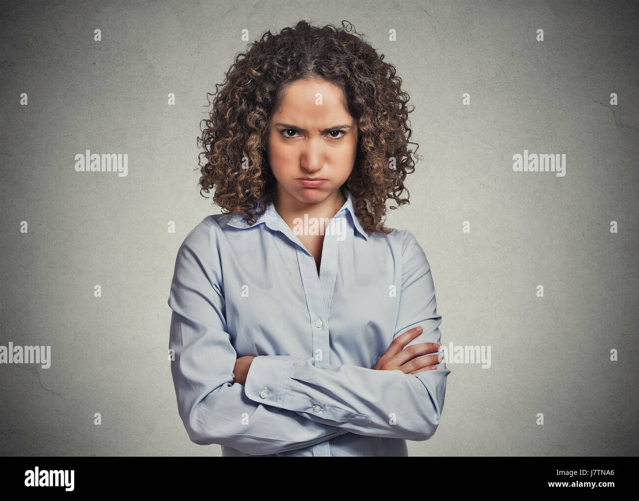 Closeup portrait of angry young woman puffing cheeks isolated on grey ...