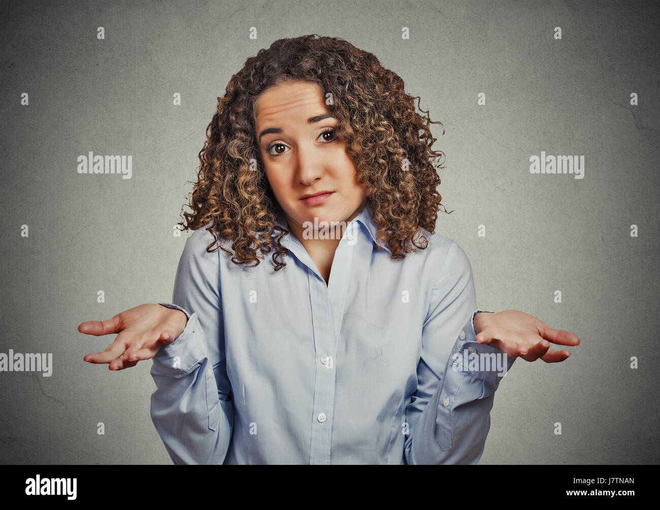 Portrait dumb young woman arms out shrugs shoulders who cares so what I ...