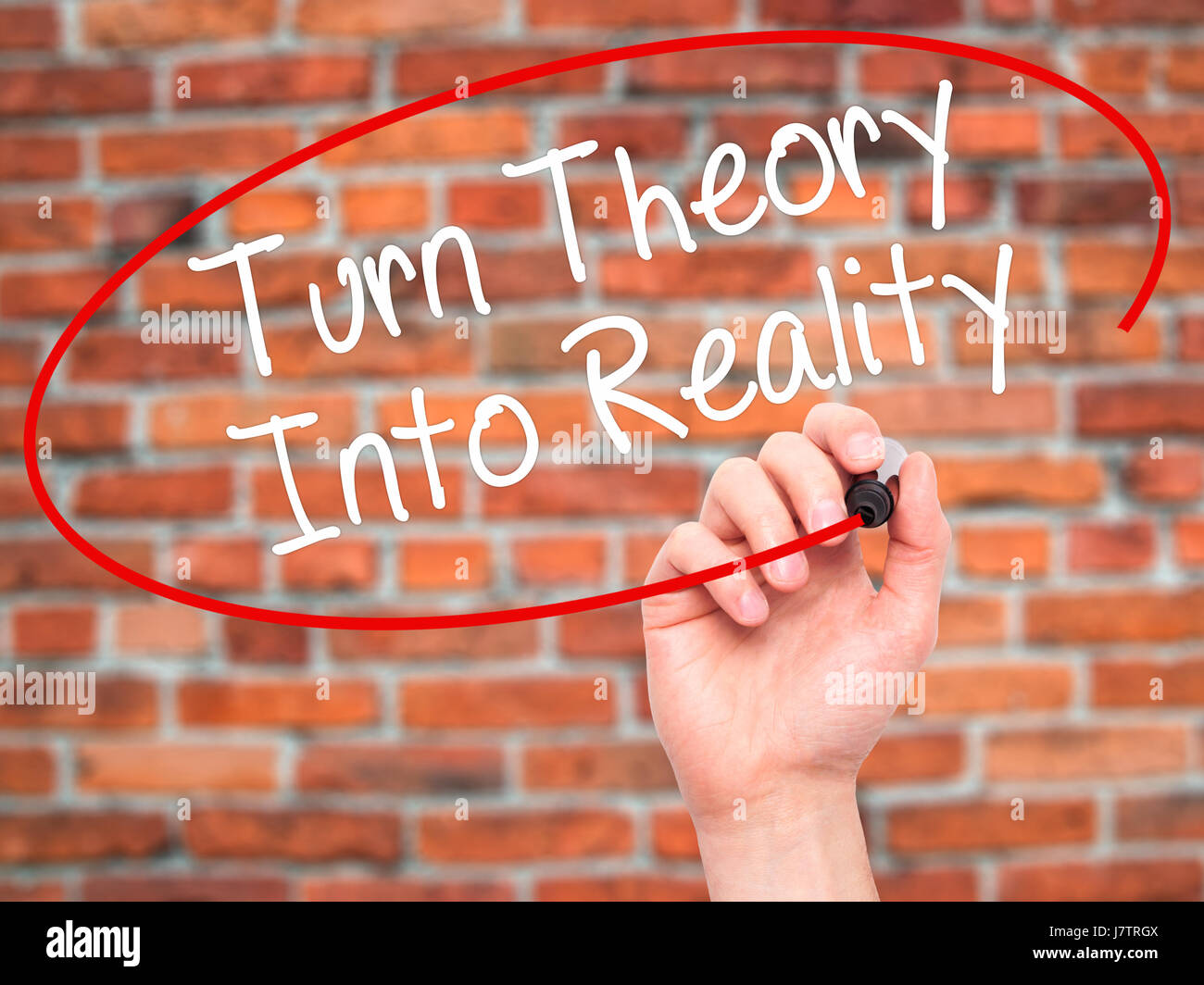 Man Hand writing Turn Theory Into Reality with black marker on visual ...