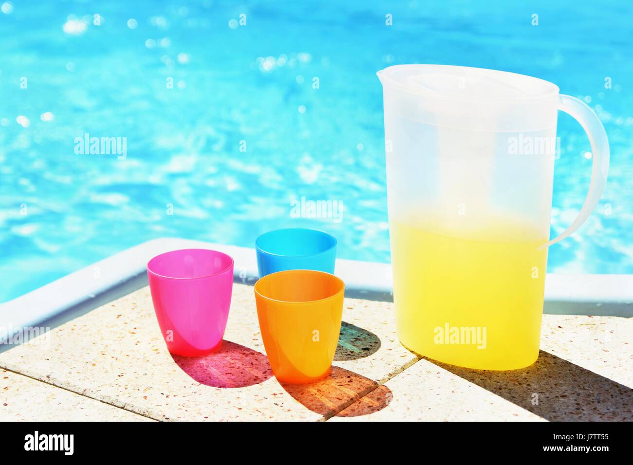 Drink in a teapot with cups at the pool. Drinking water in the hot ...
