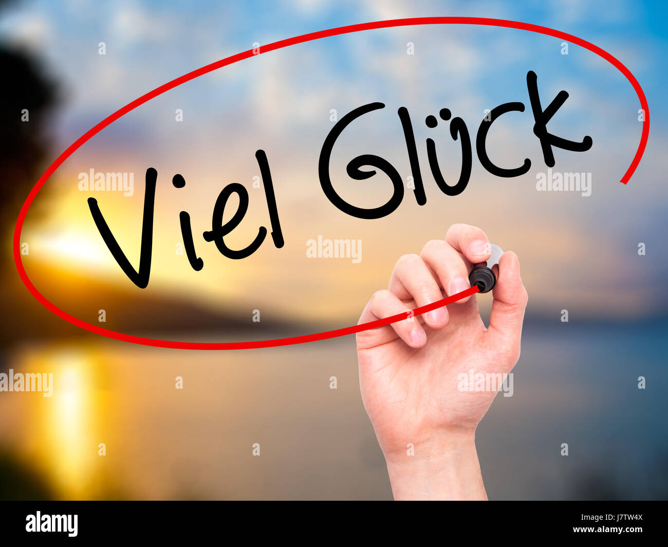 Man Hand writing Viel Gluck (Good Luck in German) with black marker on ...