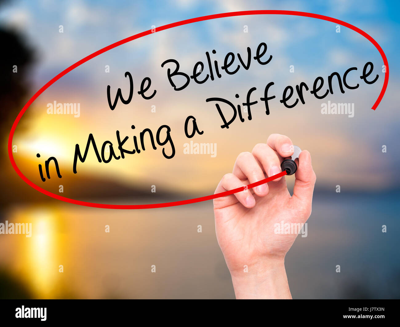 Man Hand writing We Believe in Making a Difference with black marker on ...