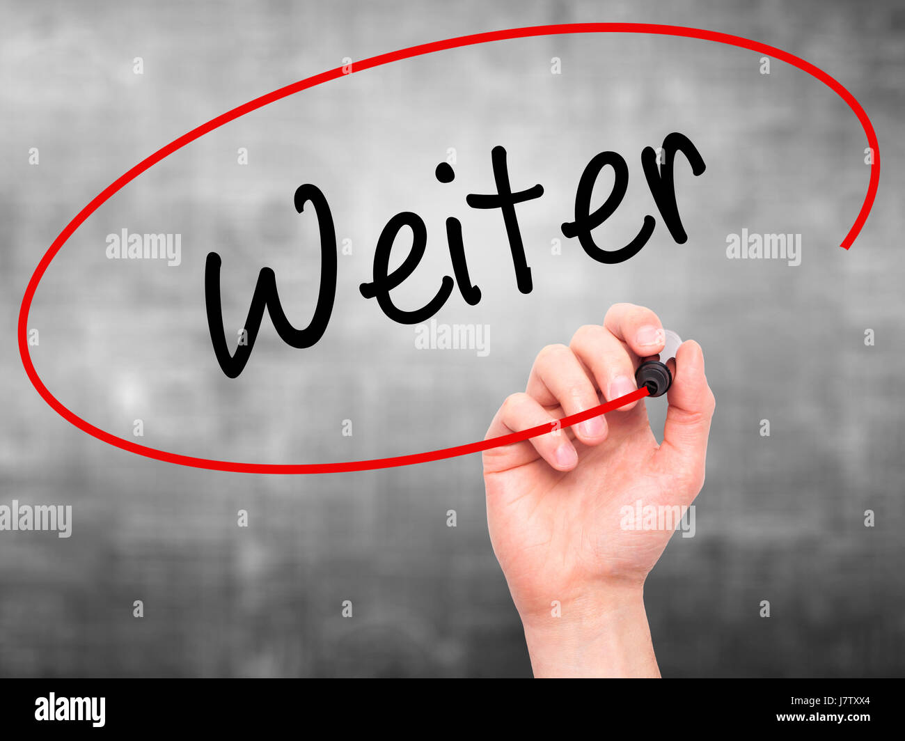 Man Hand writing Weiter (Continue in German) with black marker on ...
