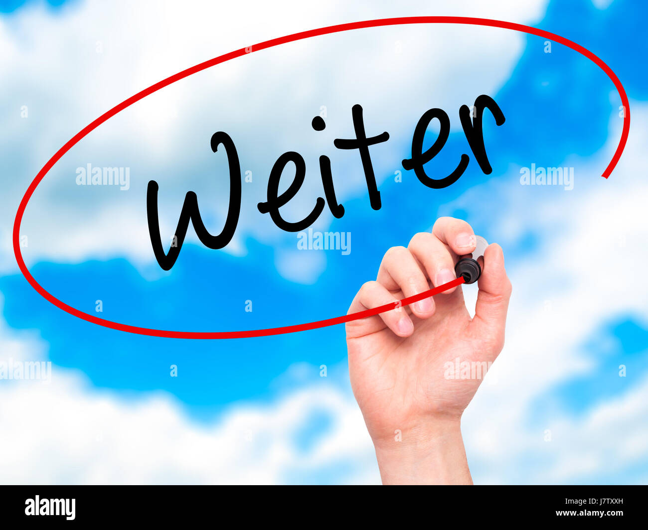 Man Hand writing Weiter (Continue in German) with black marker on ...
