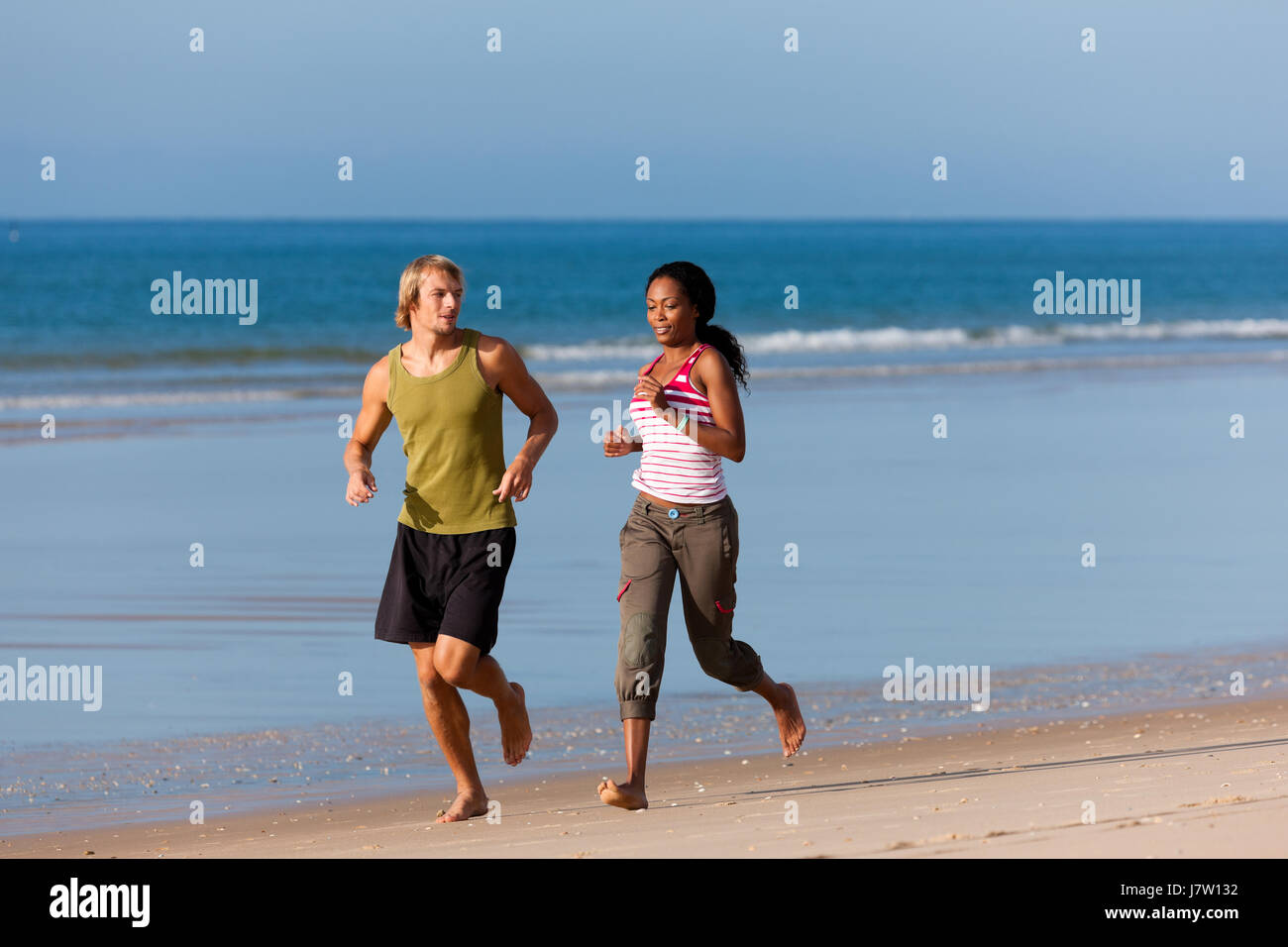 sport couple jogging on the beach Stock Photo - Alamy