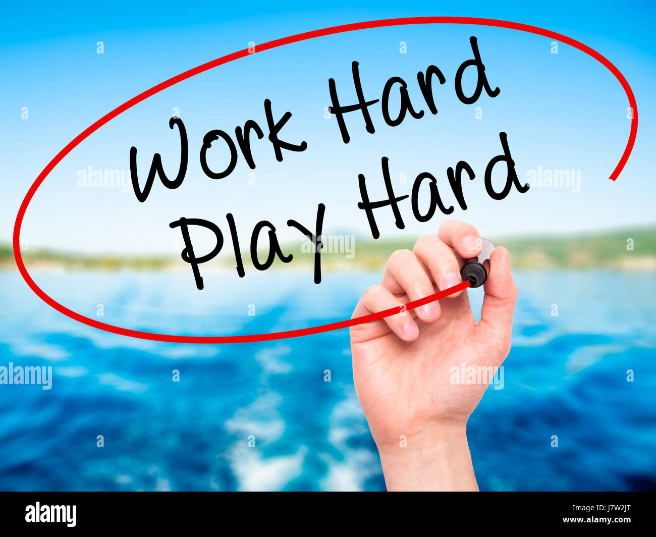 Man Hand writing Work Hard Play Hard with black marker on visual screen ...