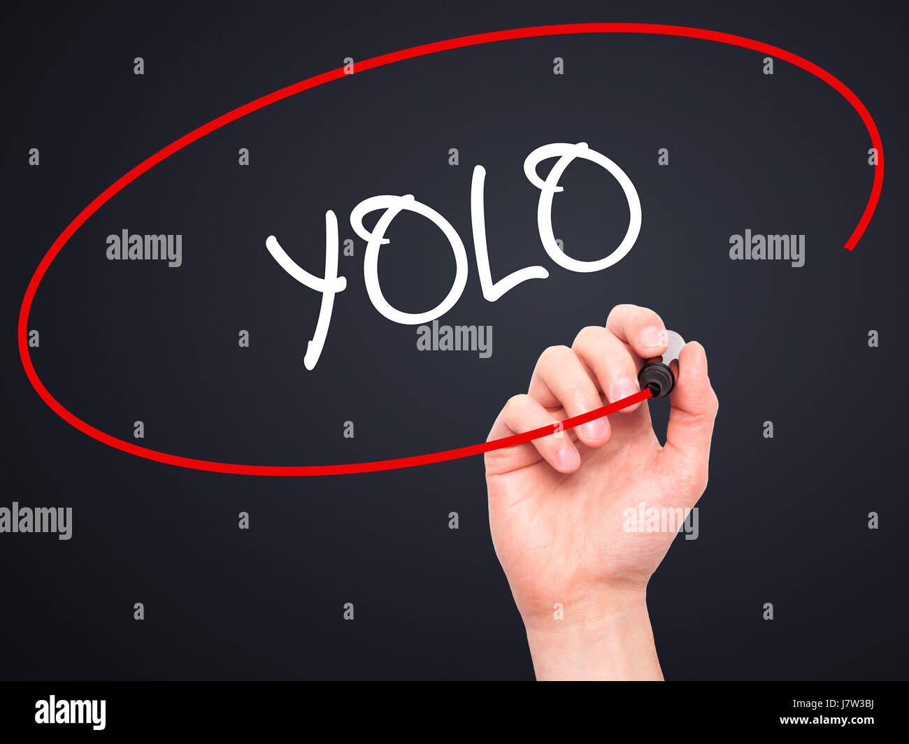 Man Hand writing YOLO (You Only Live Once) with black marker on visual ...