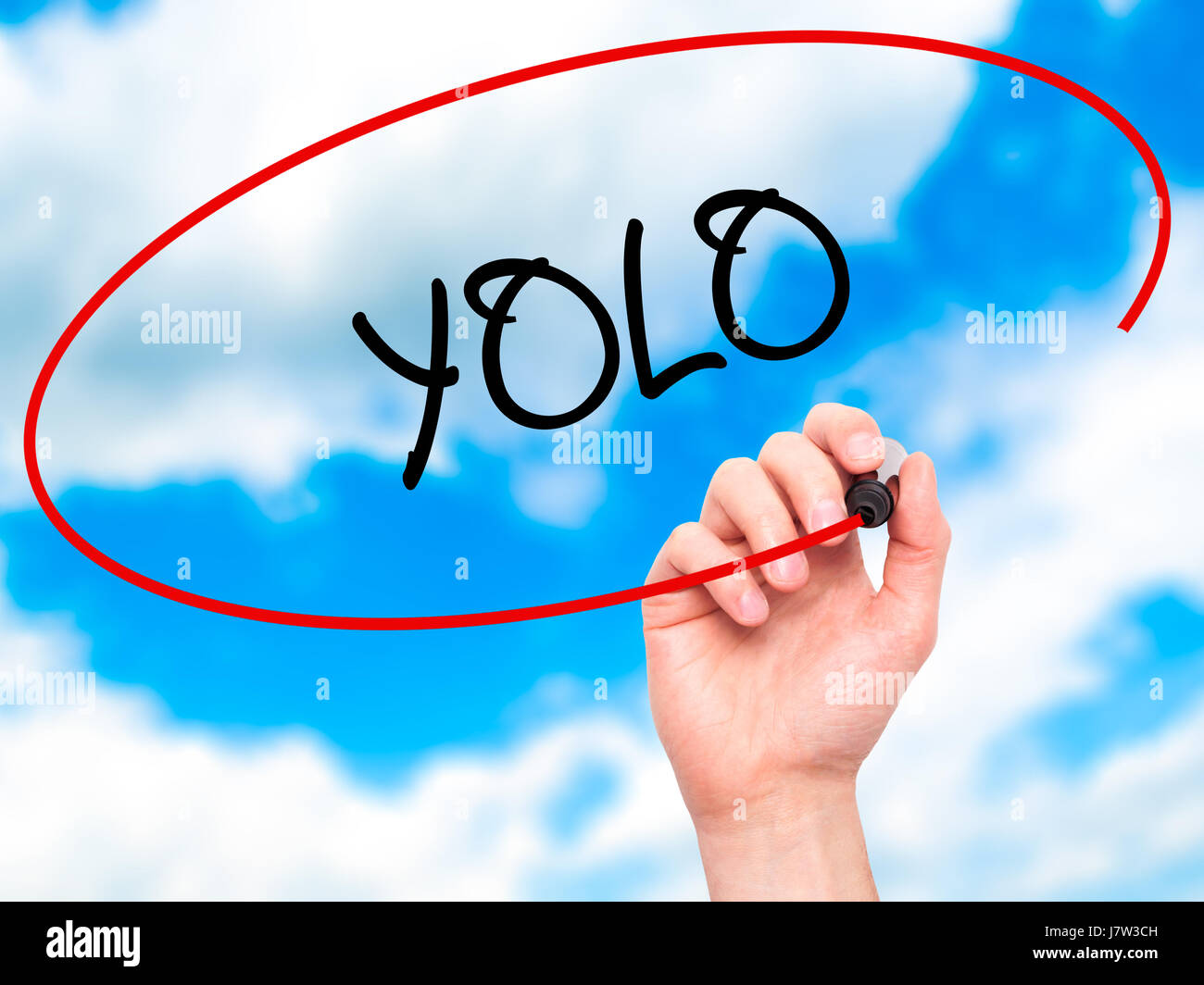 Man Hand writing YOLO (You Only Live Once) with black marker on visual ...