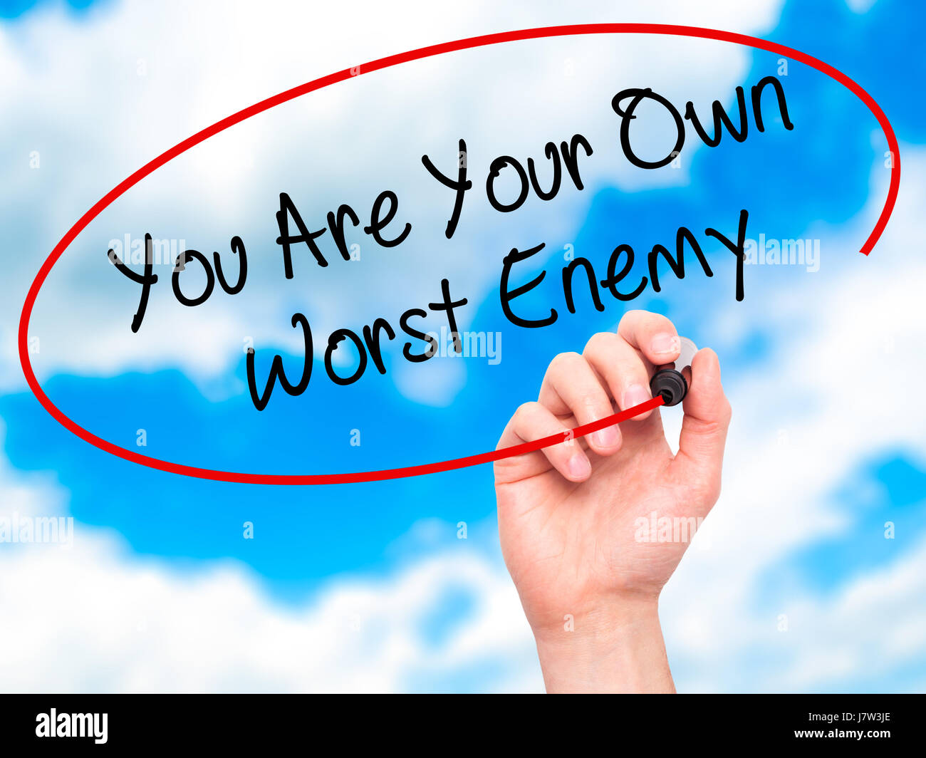 Man Hand writing You Are Your Own Worst Enemy with black marker on ...