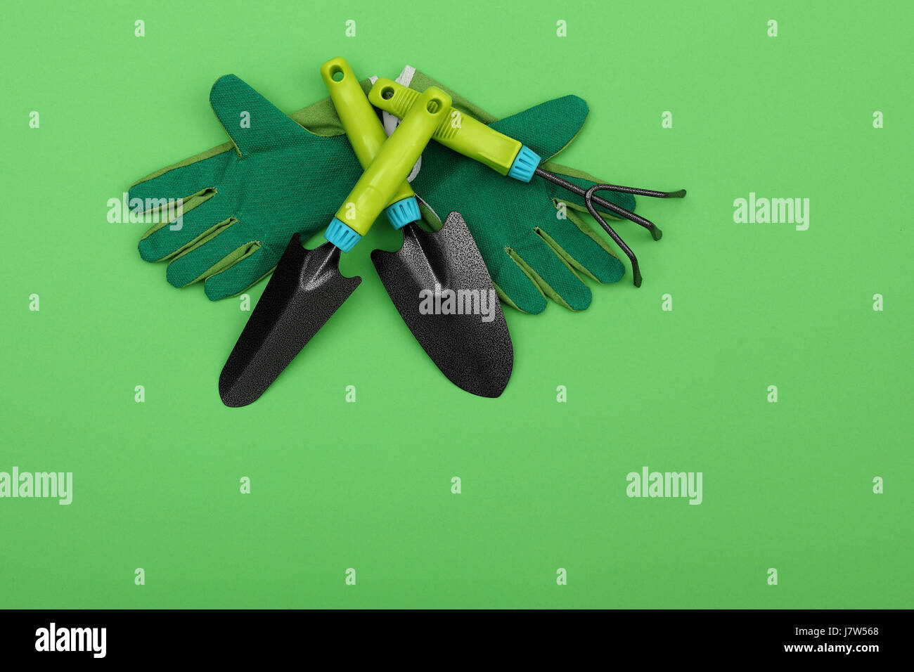 Gardening tools on a green background Stock Photo - Alamy