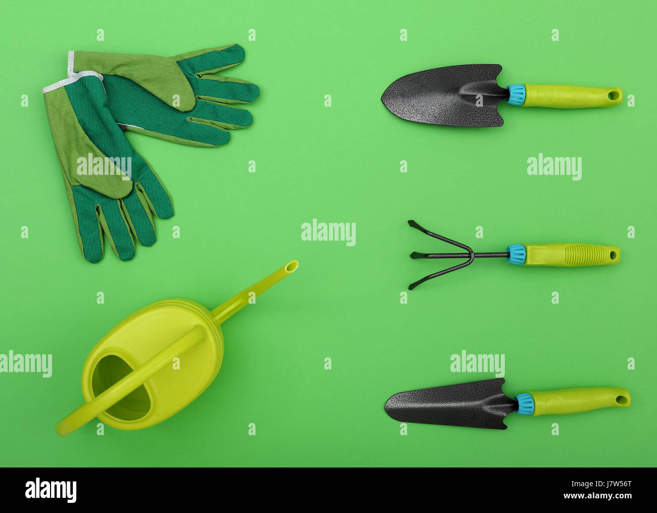 Gardening tools on a green background Stock Photo - Alamy