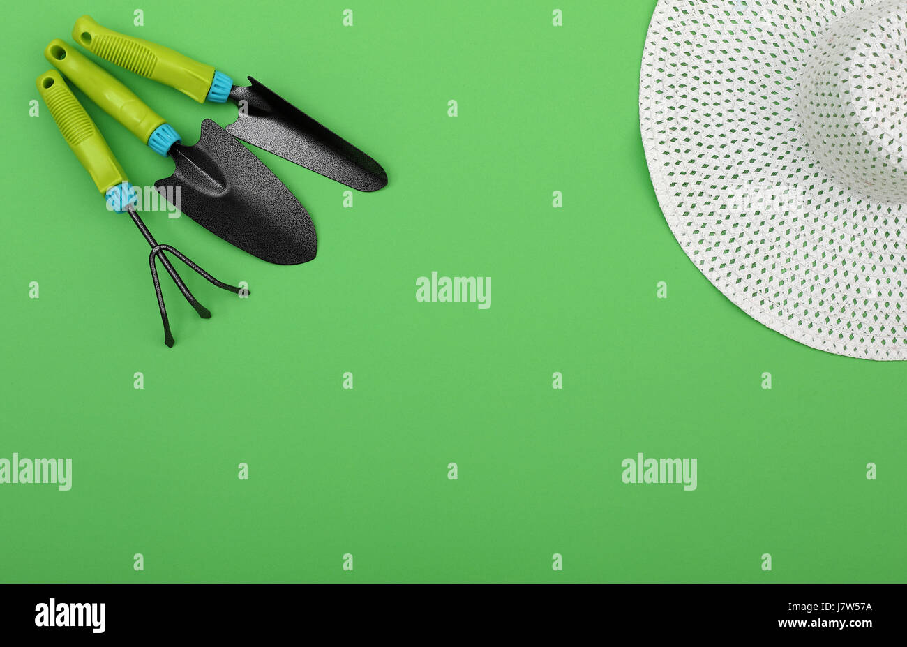 Gardening tools on a green background Stock Photo - Alamy