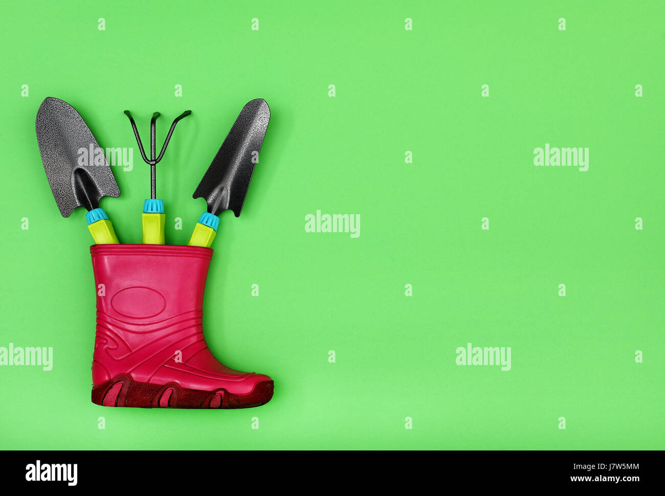 Gardening tools on a green background Stock Photo - Alamy