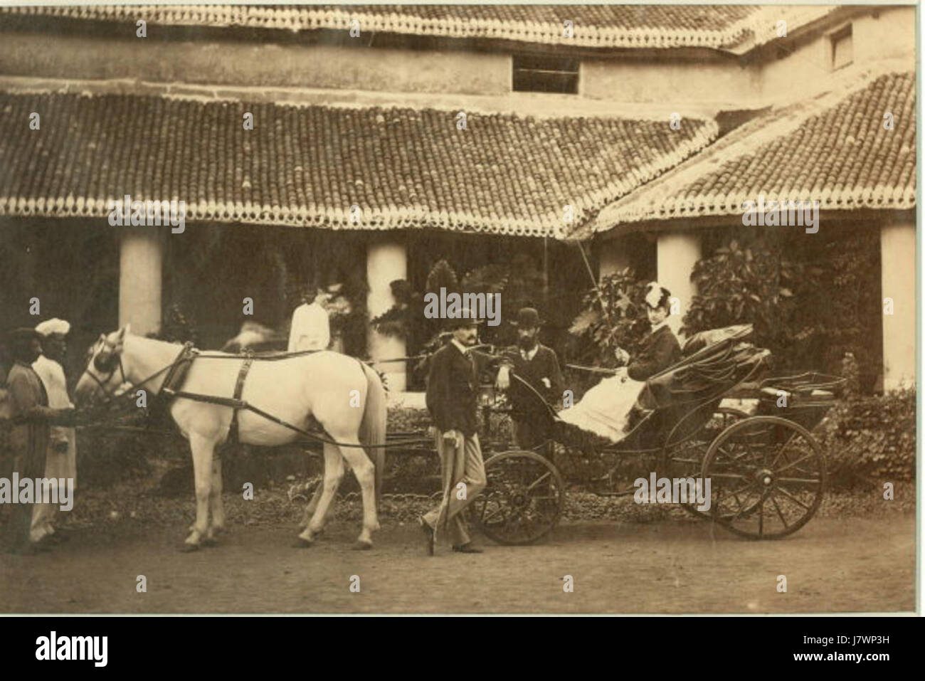 This image depicts a British family standing in front of their home in ...
