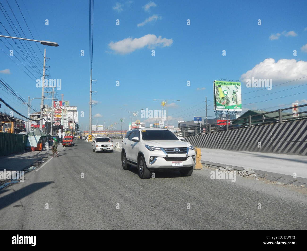 The image depicts the Olongapo Gapan Road in Pampanga, a key route ...