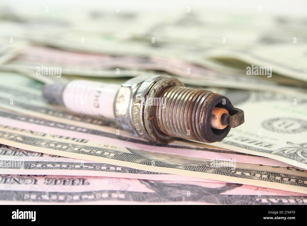spark plug on dollar bills Stock Photo - Alamy