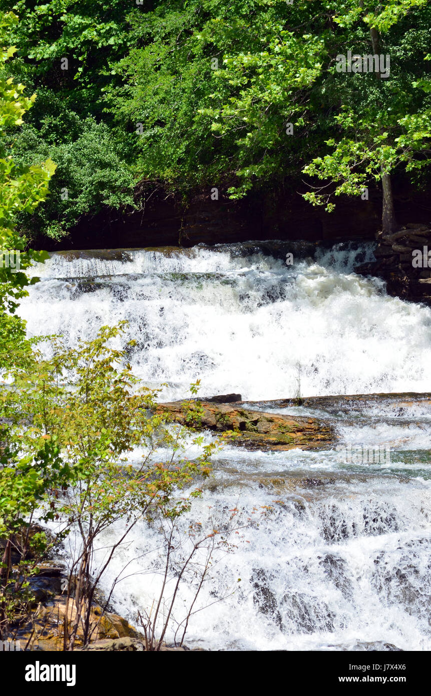 A waterfall flows down over rocky land Stock Photo - Alamy