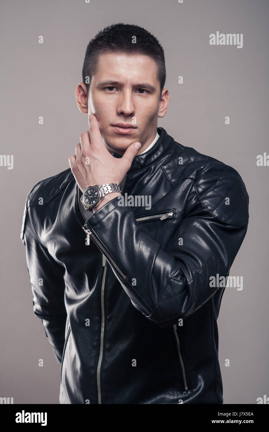 one young adult man only, hand touching face, looking tense, looking to ...