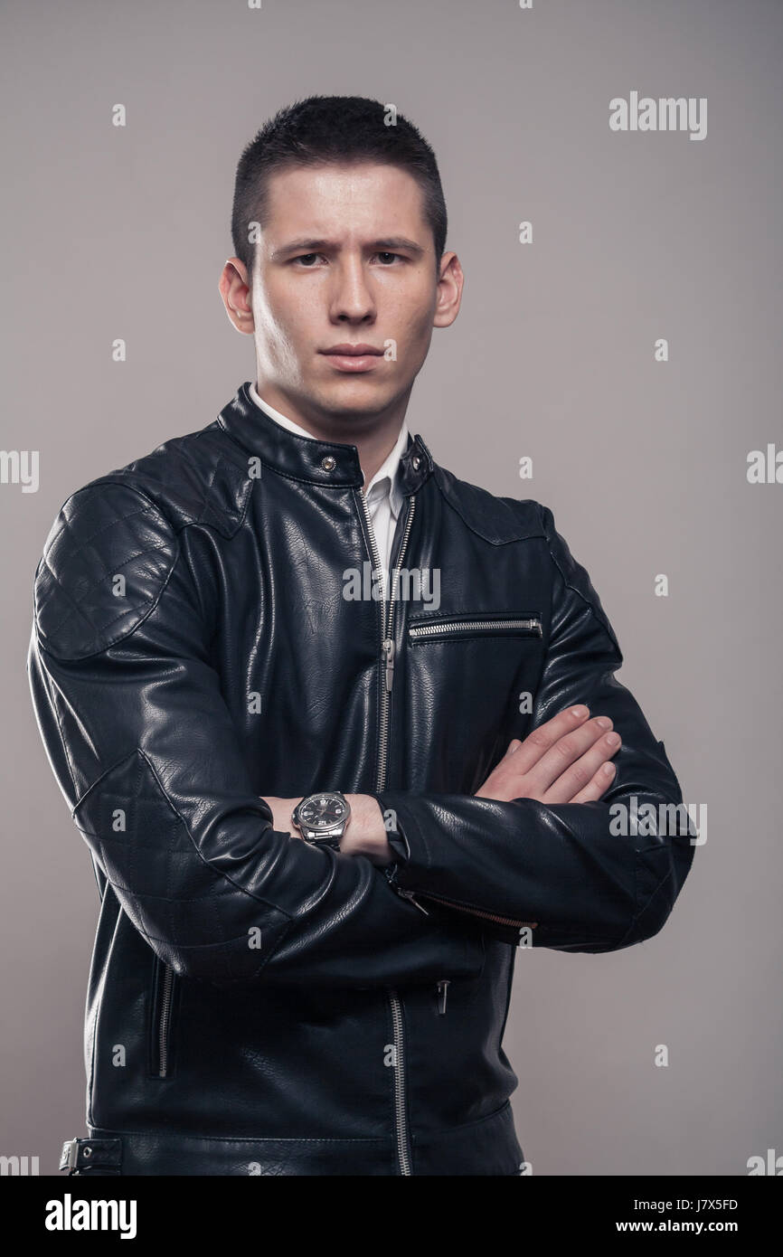 one young adult man only, looking sideways, looking tense, leather ...