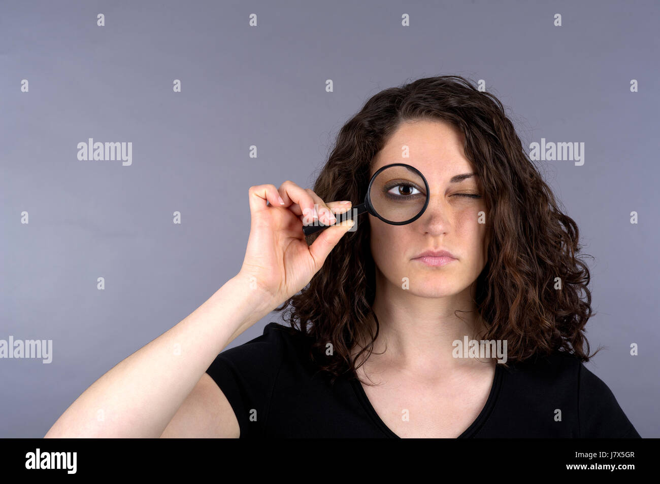 woman with magnifying glass in front of face Stock Photo - Alamy