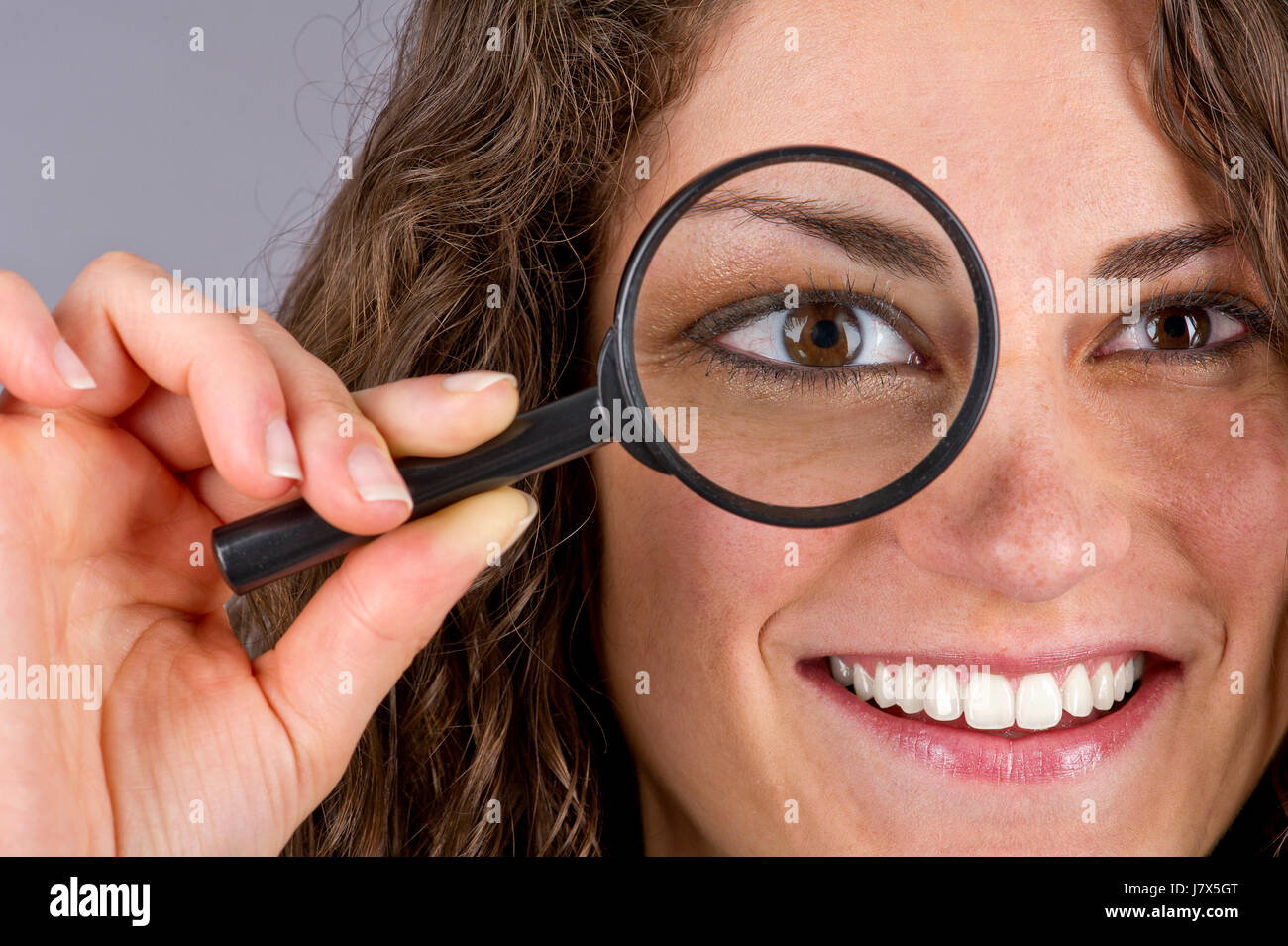 woman with magnifying glass in front of face Stock Photo - Alamy
