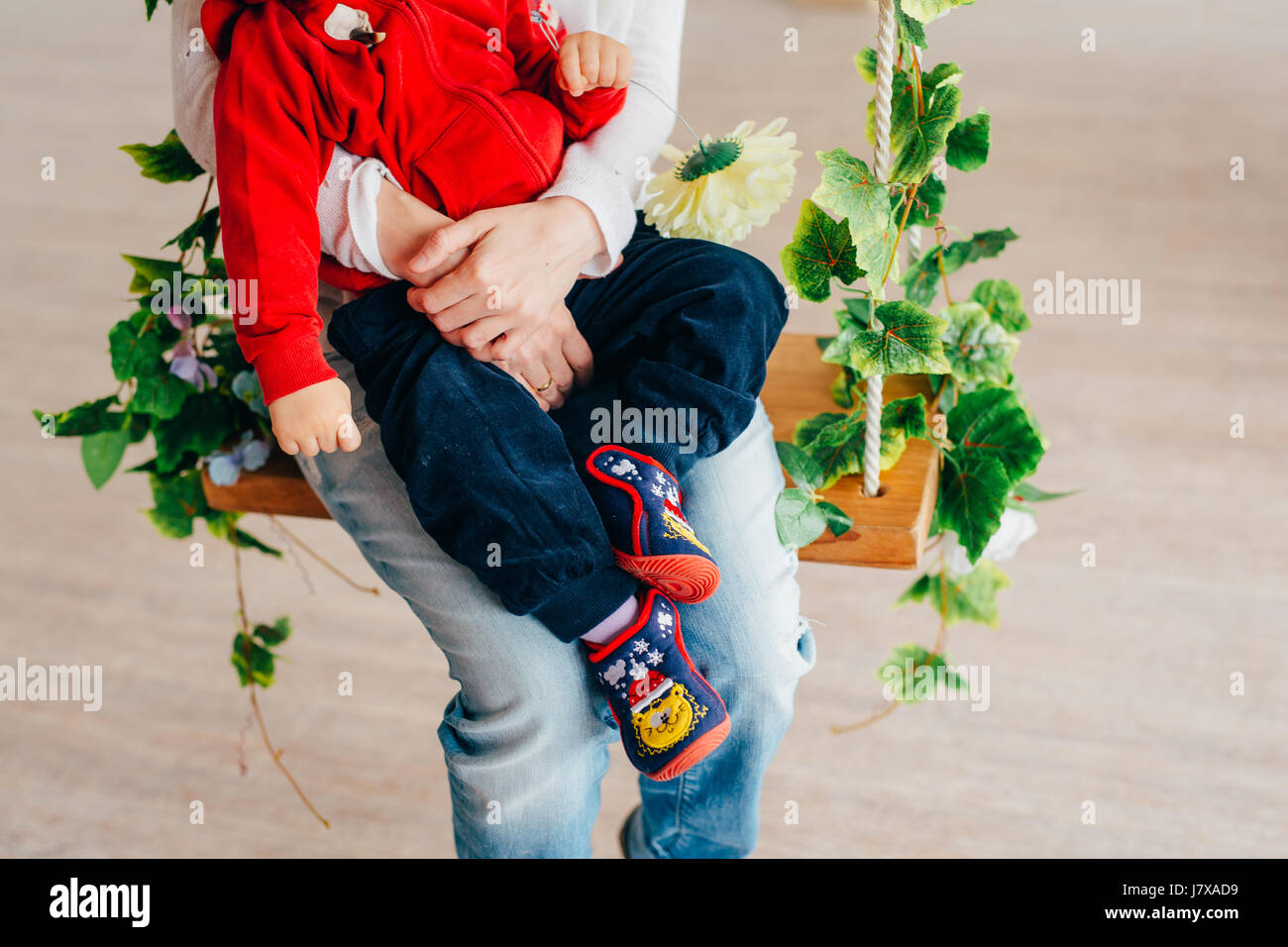 Parents hold the child in their arms. A little child with parent Stock ...