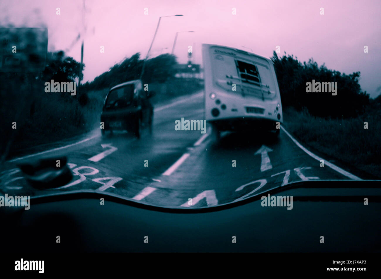 Wavy, distorted view of road and cars in front. Colours are surreal ...