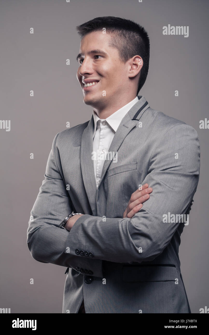 one young adult man, happy smiling sideways, formal clothes, coat, white shirt, upper body, gray ...