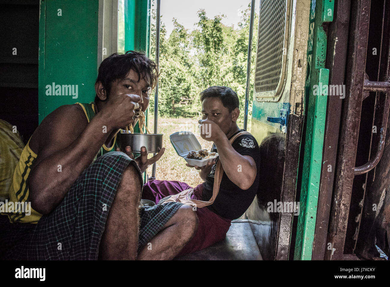 Two guys are getting lunch between two carriages of the train. Due ...