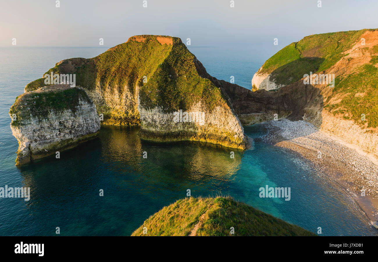 Sea erosion along the high chalk cliffs on a fine summer morning with ...
