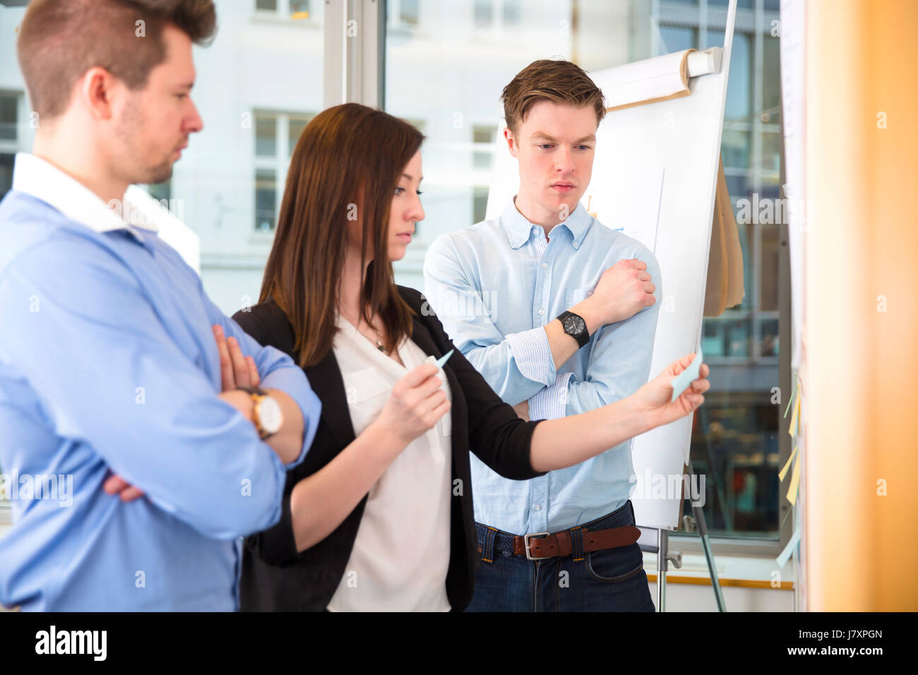 Young coworkers communicating in office hi-res stock photography and ...