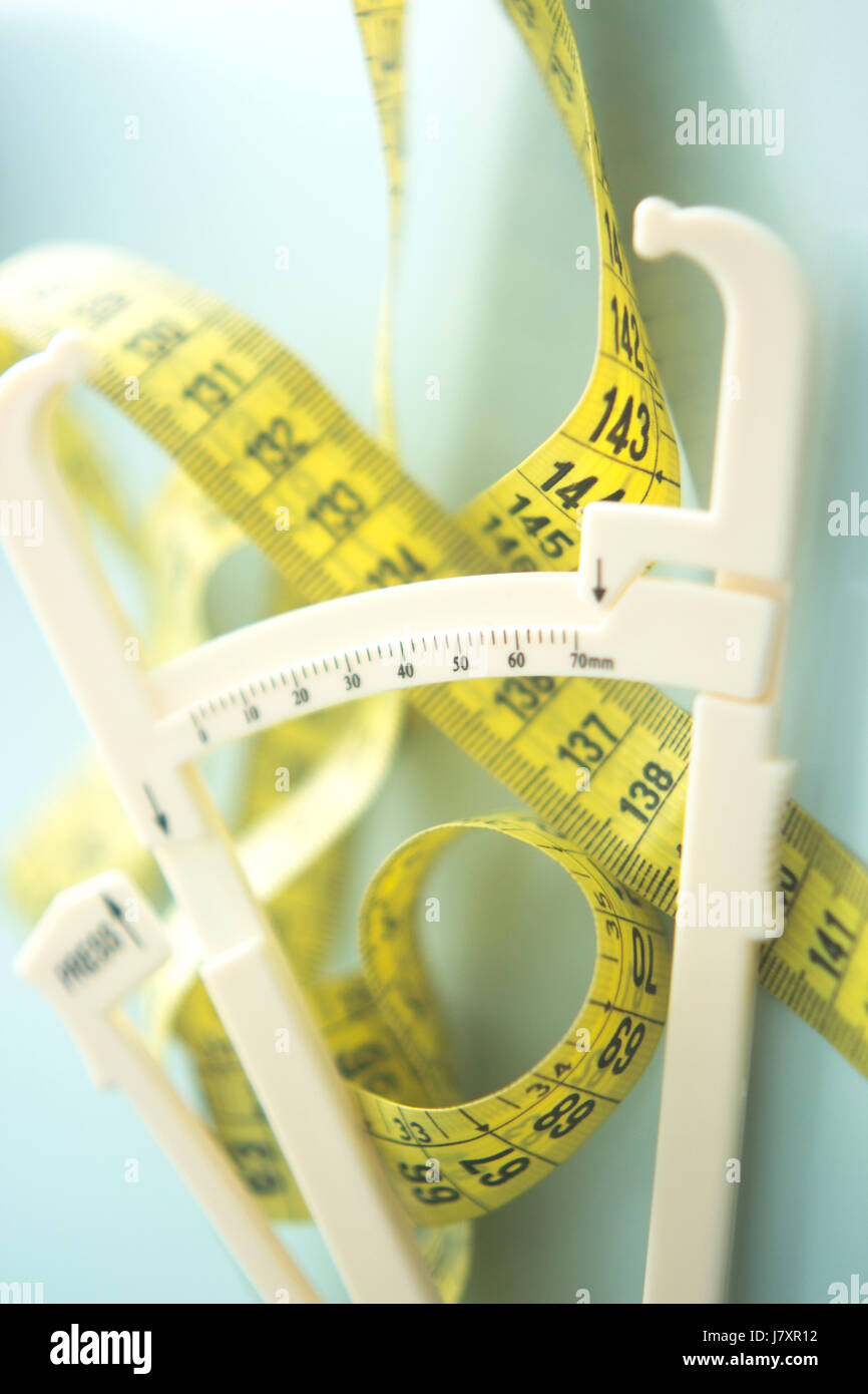 Fat caliper and measuring tape used to measure waistline, bodyfat ...
