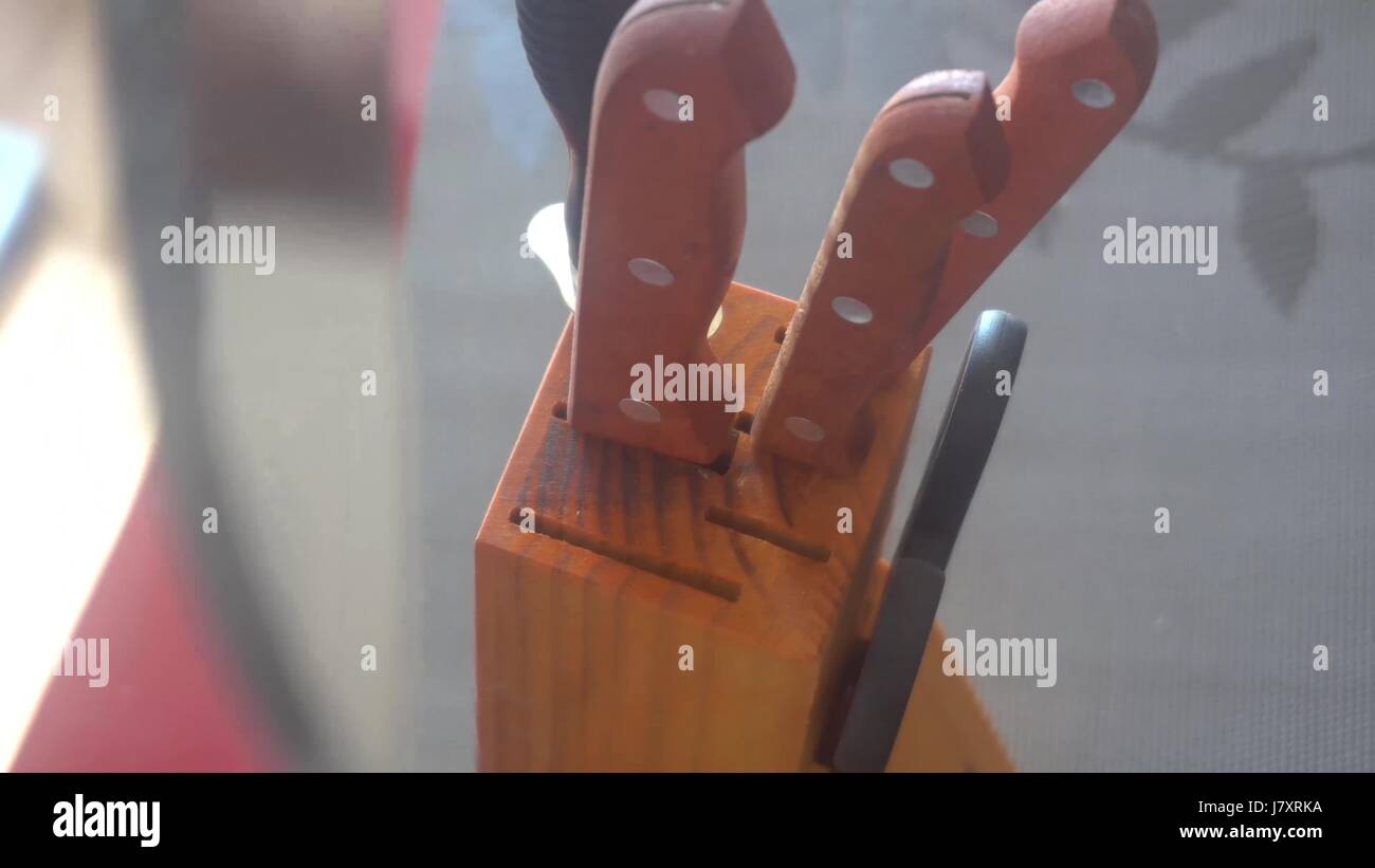 Pulling a knife out of the knives block and putting it back at it's ...