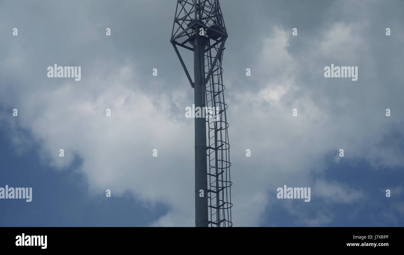 Mobile telecommunication tower on the background of the rainy clouds ...