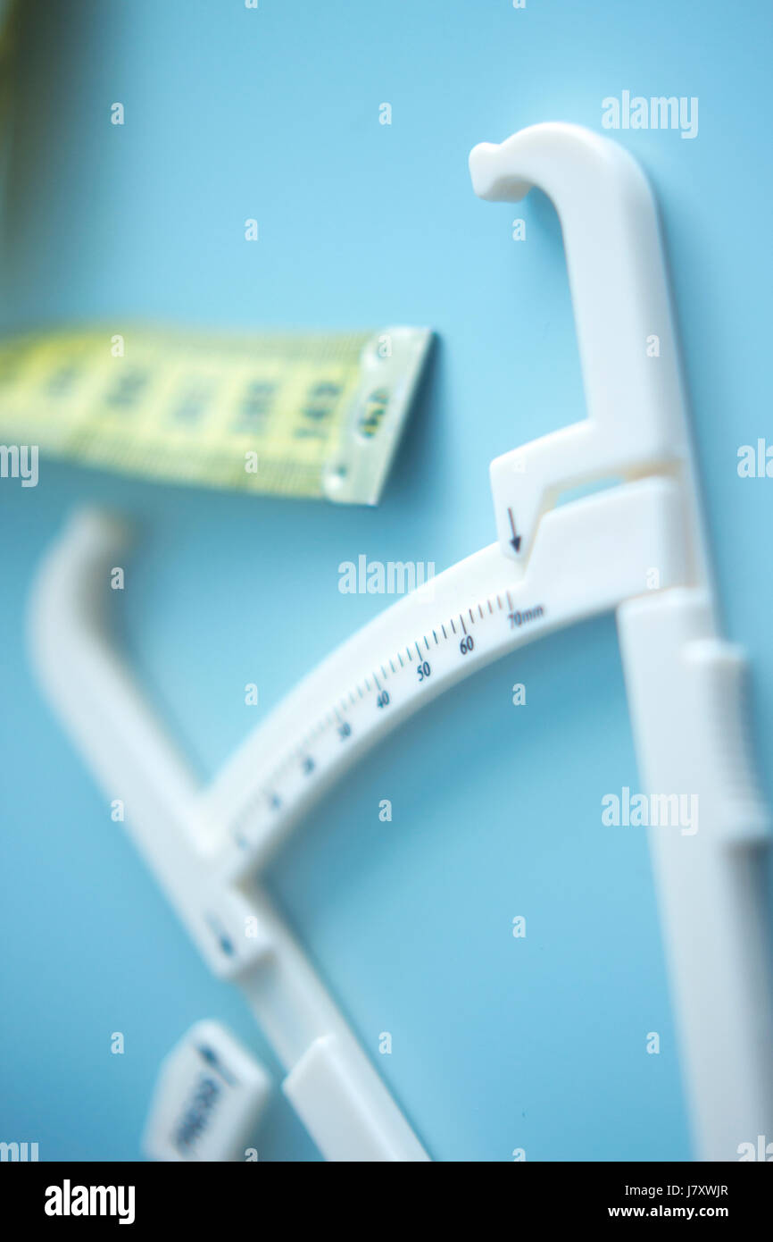 Fat caliper and measuring tape used to measure waistline, bodyfat ...
