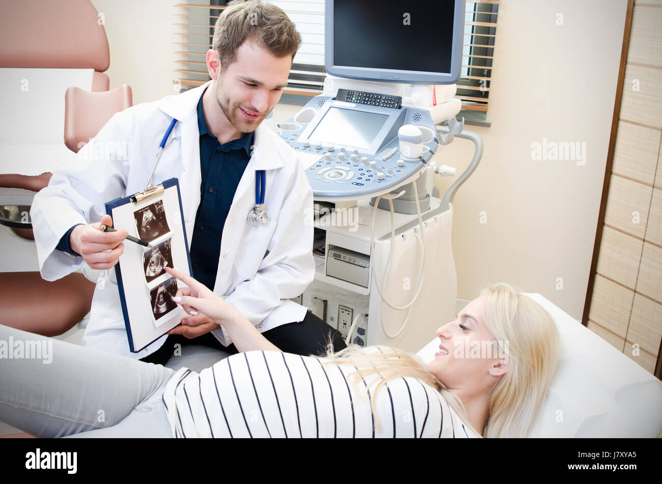 Doctor showing baby ultrasound image to pregnant woman. showing ...
