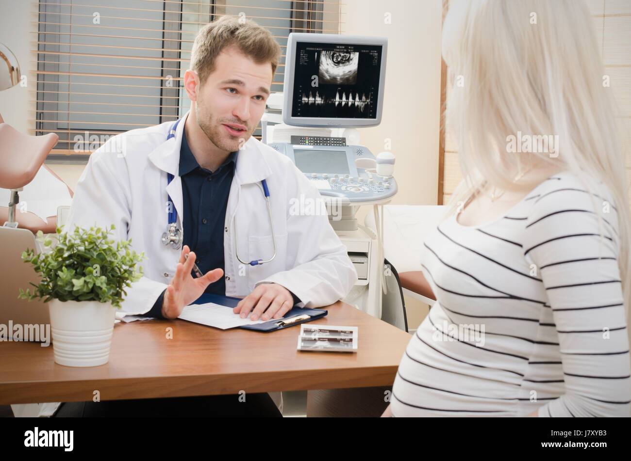 Doctor showing baby ultrasound image to pregnant woman. showing ...