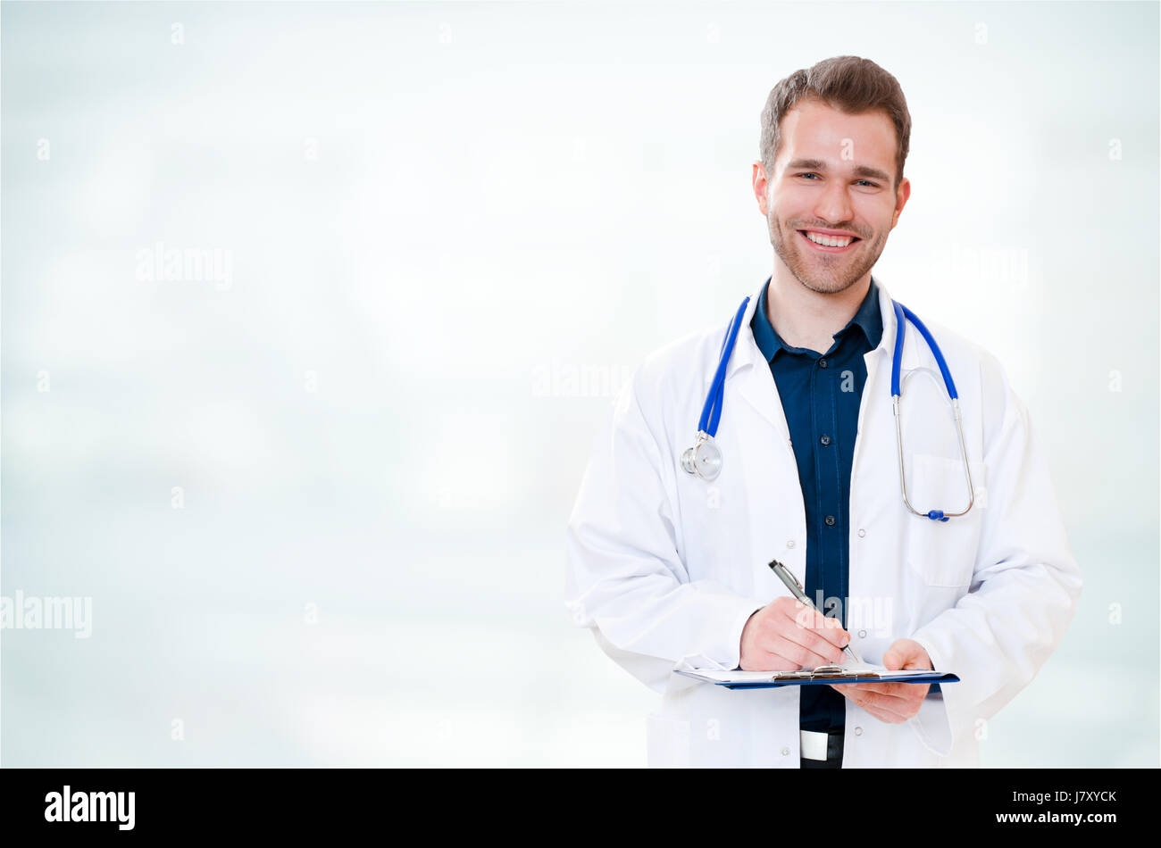 Handsome young smiling doctor with clipboard. doctor front view ...