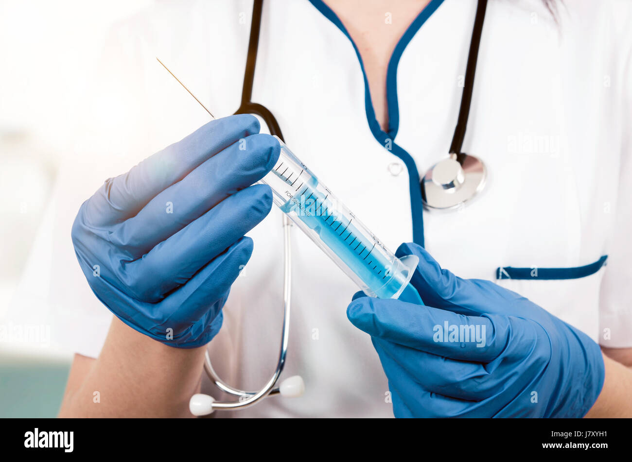 Woman doctor with gloves holding medical injection syringe and ...