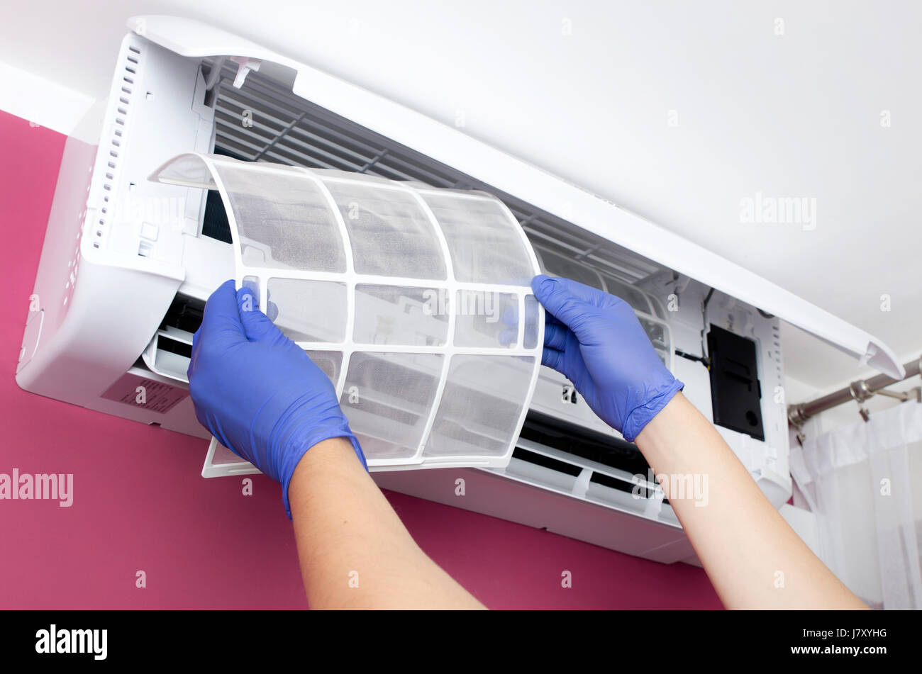 Air conditioner cleaning. Man in gloves checks the filter Stock Photo ...