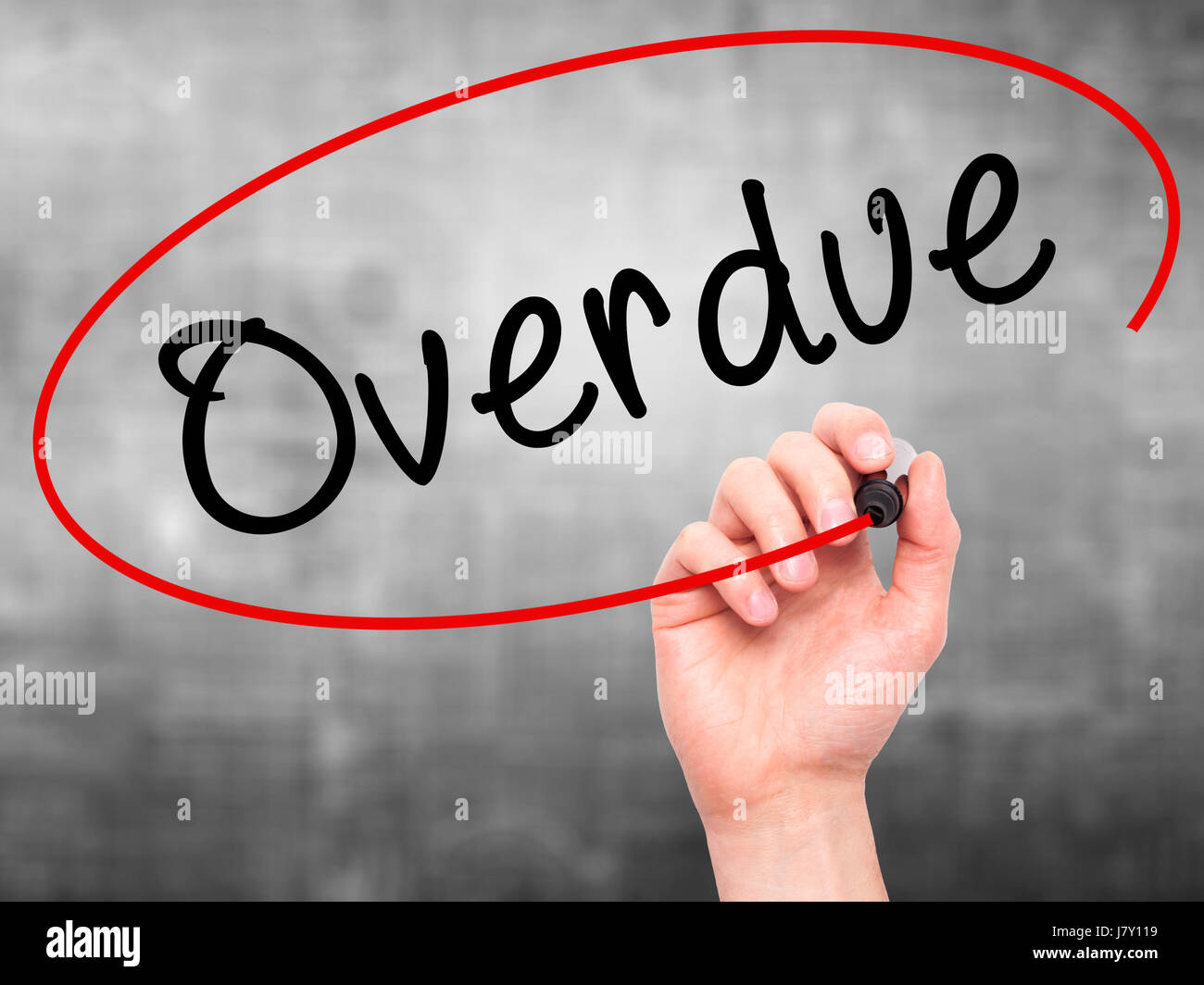 Man Hand writing Overdue with marker on transparent wipe board ...