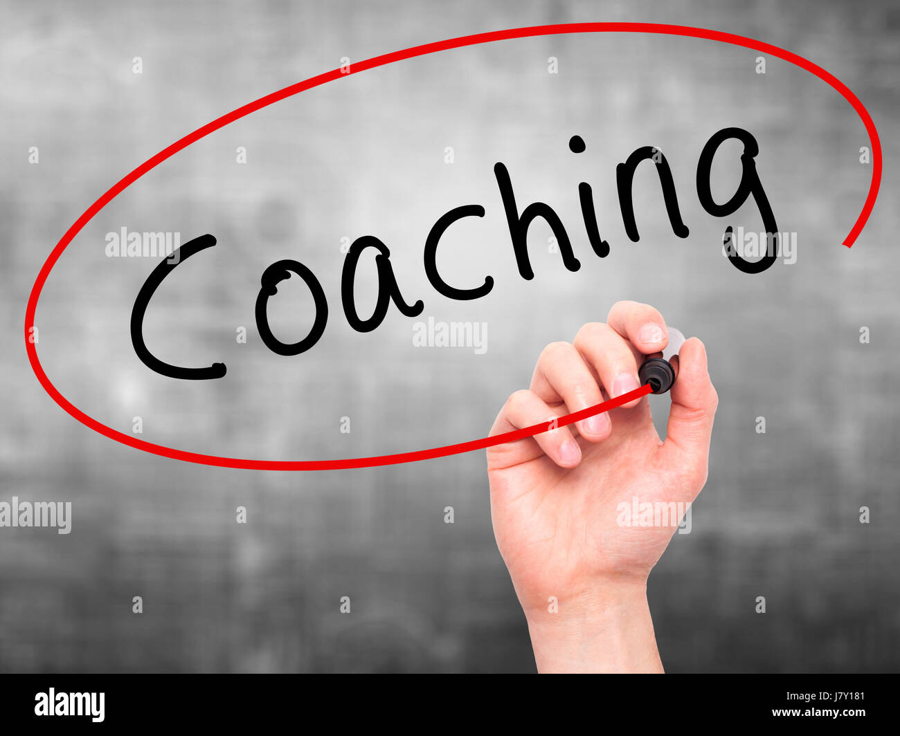 Man Hand writing Coaching with marker on transparent wipe board ...